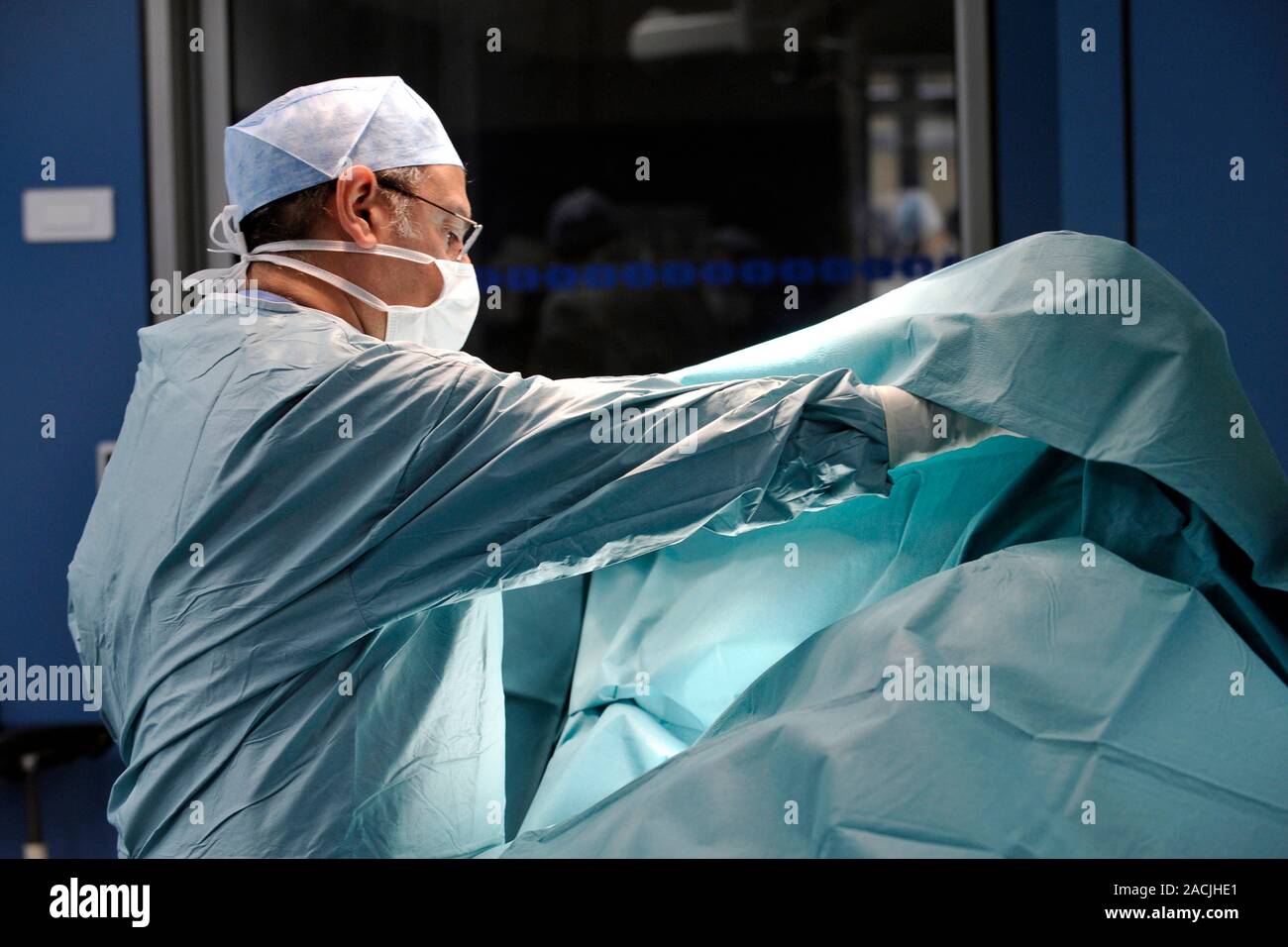 Surgery. Surgeon adjusting a surgical sheet during surgery Stock Photo ...