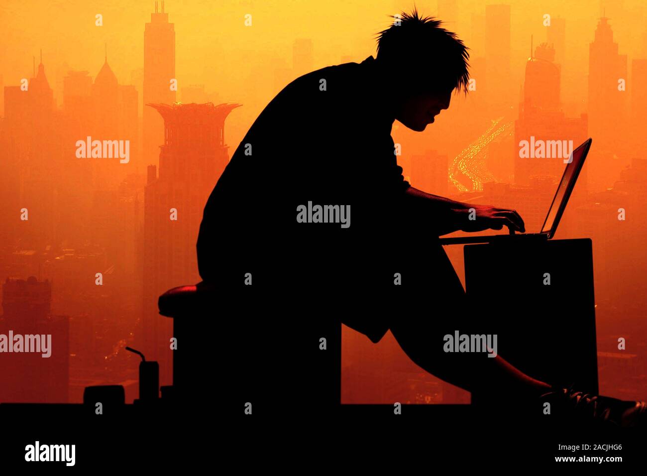 Computer hacker, artwork. Man sitting on a bench with a wireless laptop ...