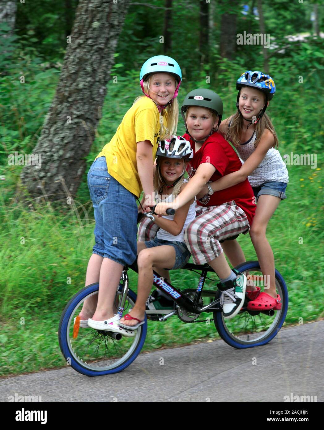 Children riding a bike. Child riding a bicycle with three other ...