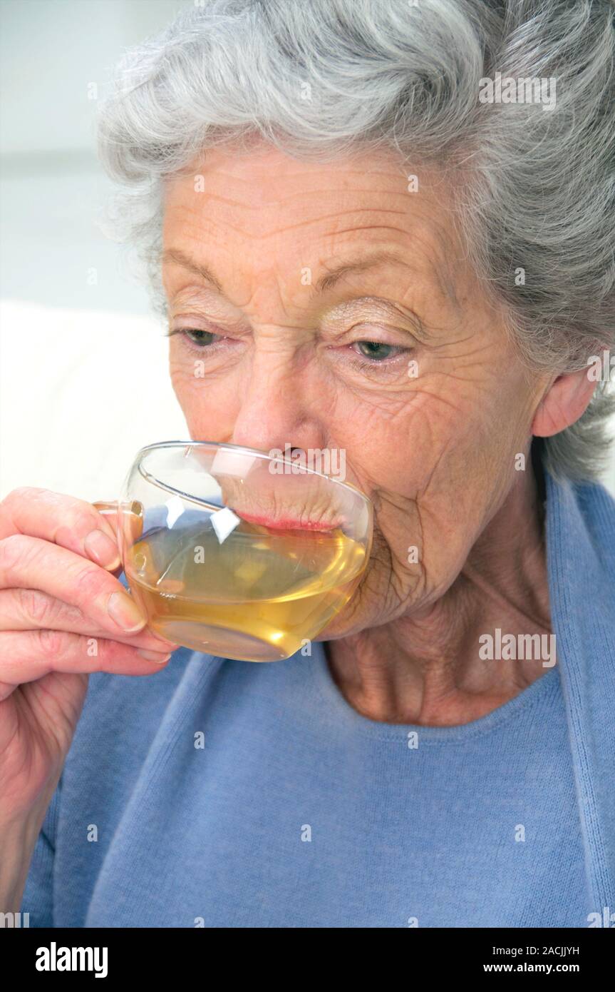 Elderly woman drinking herbal tea Stock Photo - Alamy