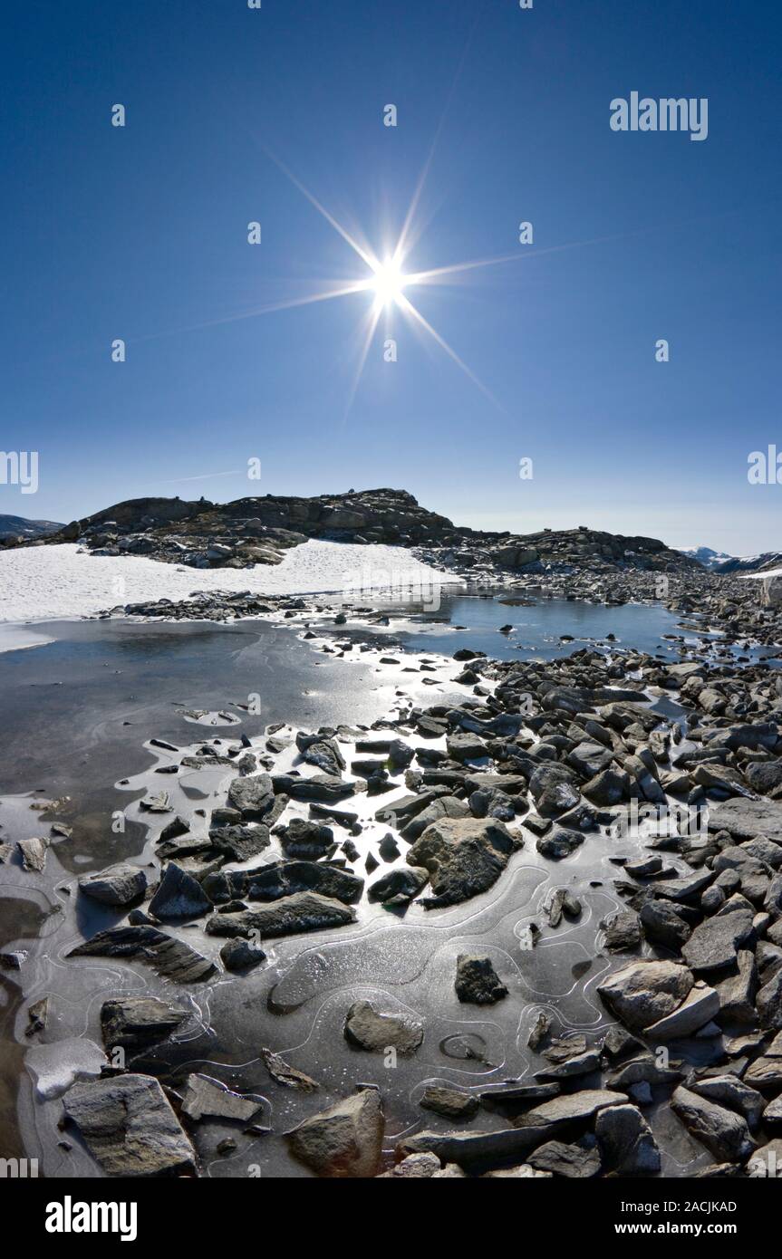 Sun over a lake. Sunlight reflecting from a partially frozen lake ...