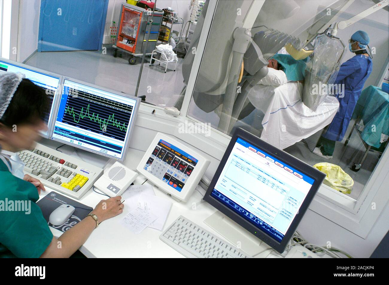 Coronary angiography. Medical staff performing an angiogram of the ...