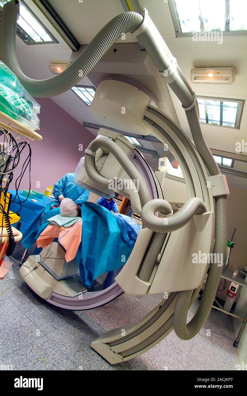 Coronary angiography. Medical staff performing an angiogram of the ...