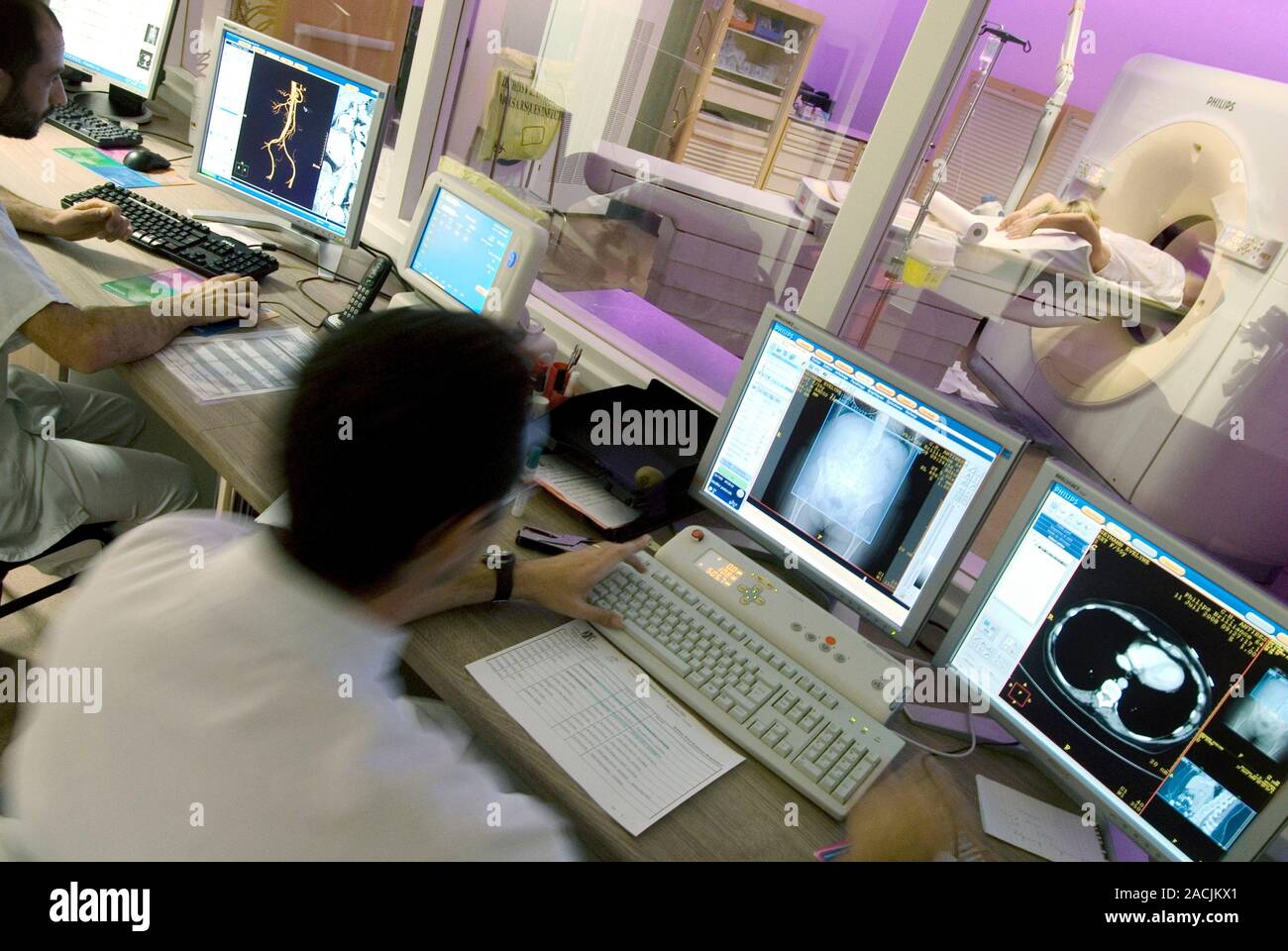 CT scan. Radiographers taking computed tomography (CT) scans of a ...