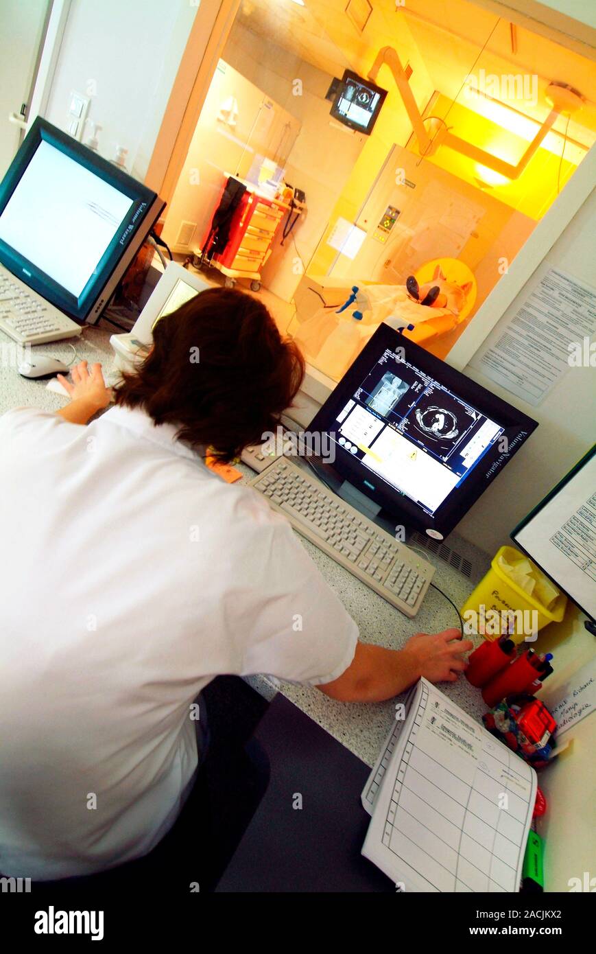 CT scan. Radiographer taking computed tomography (CT) scans of a female ...