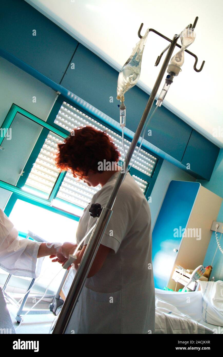 Hospital treatment. Nurse with a patient undergoing an intravenous (IV ...