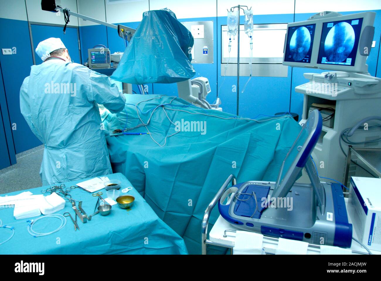 Cardiac surgeon in a hospital operating theatre conducts surgery on a ...