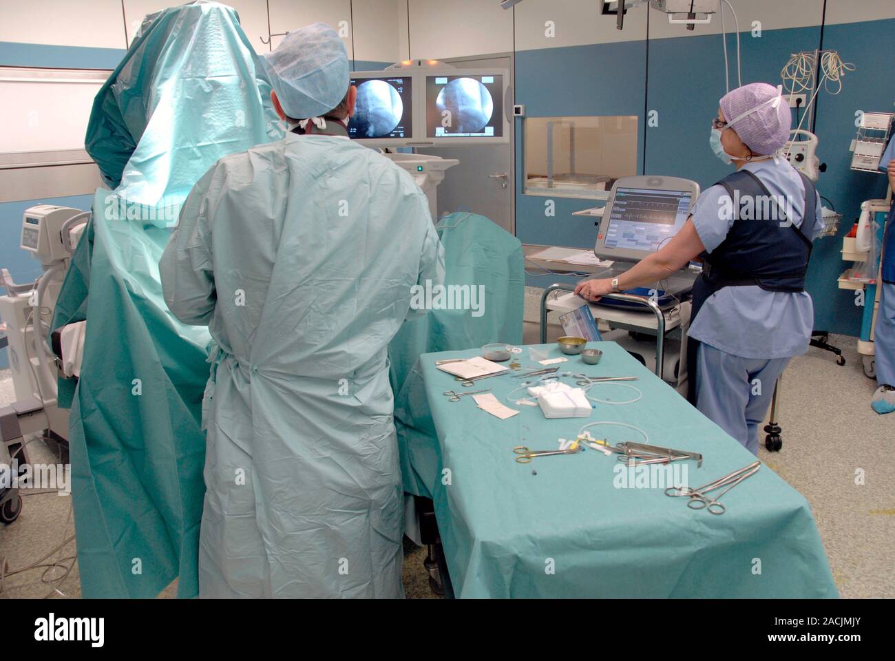 Cardiac surgeons in a hospital operating theatre conduct surgery on a ...