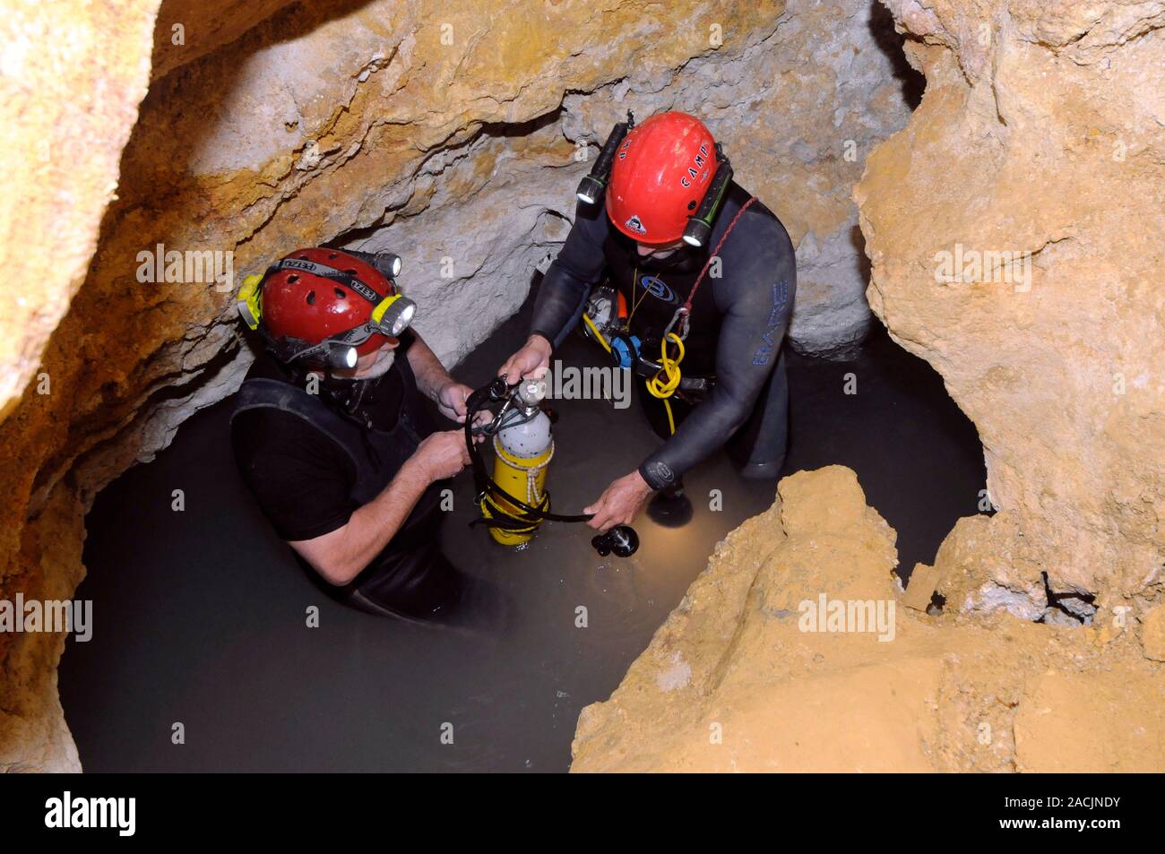 Cave research, Romania. Researchers preparing to dive in a flooded ...