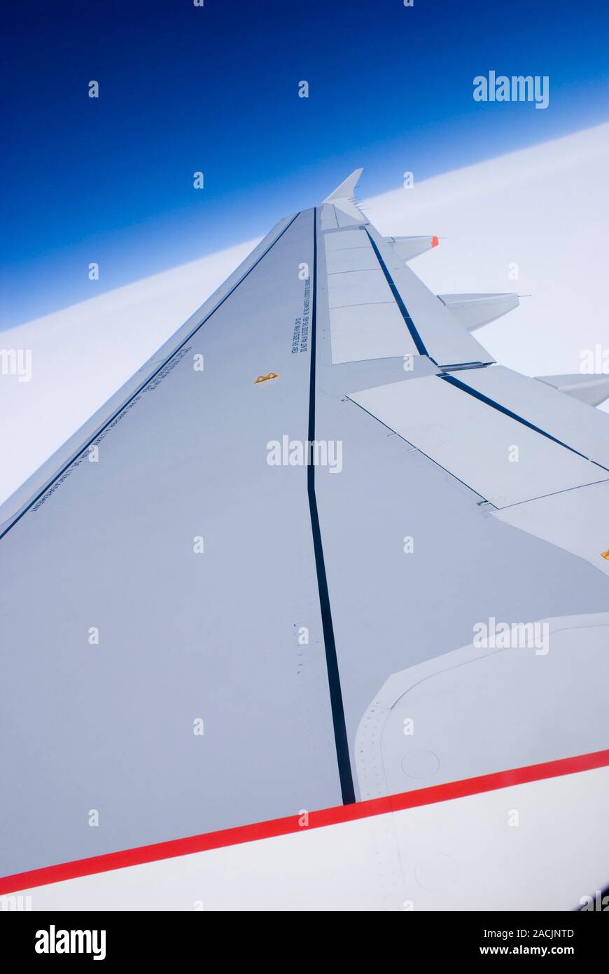 Aircraft wing and blue sky, showing tilted horizon Stock Photo - Alamy