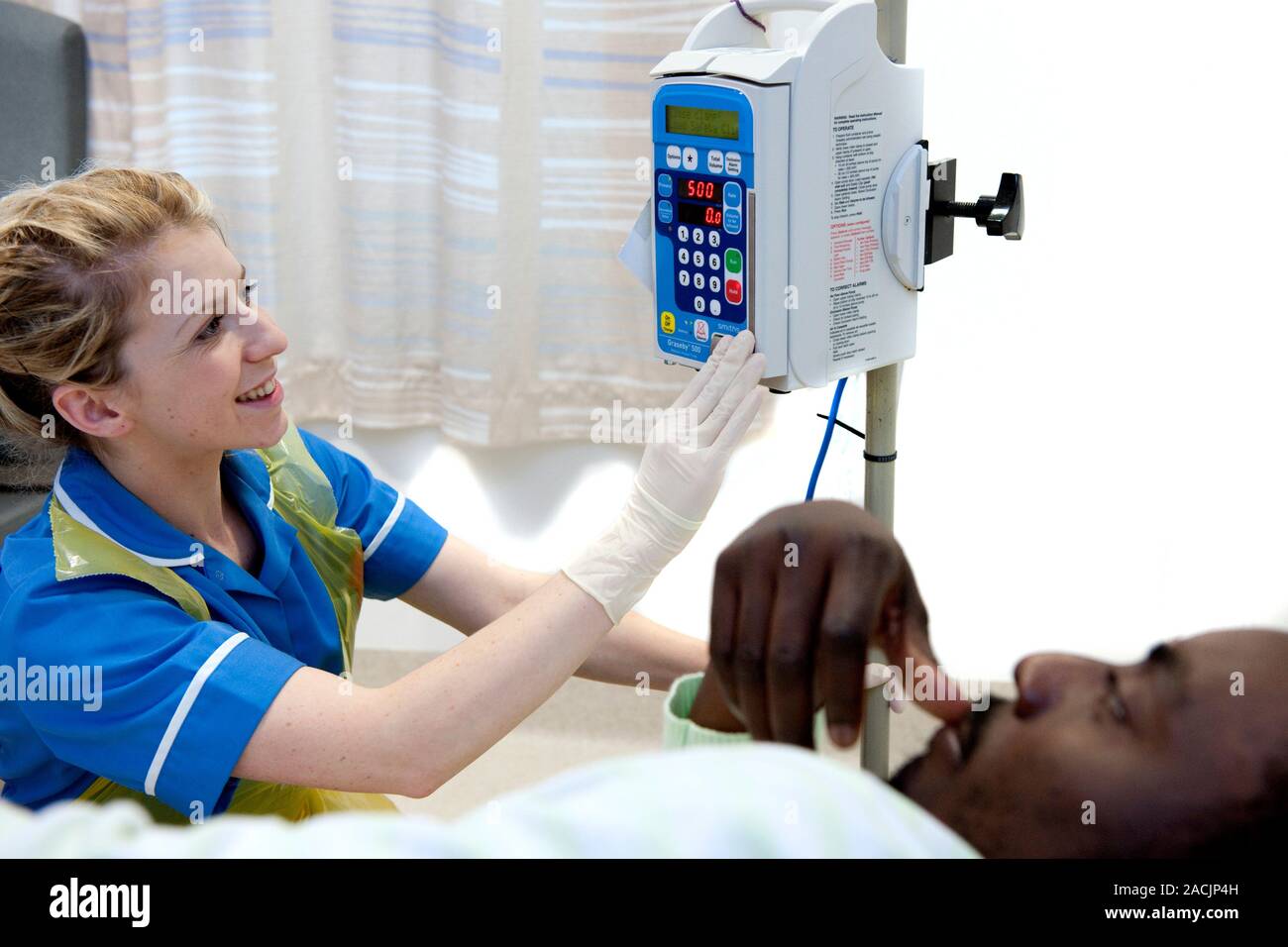Infection control nursing. Nurse adjusting a monitor being used on a ...