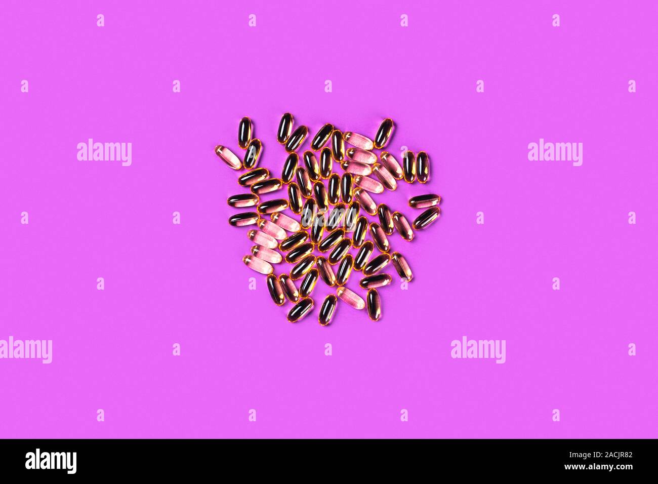 Purple table with scattered Omega 3 capsules. Flat lay, top view, copy ...