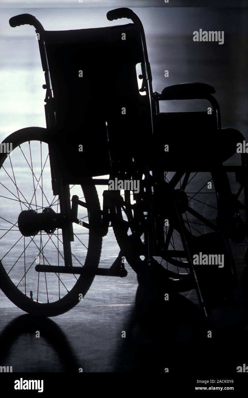 Empty wheelchair. Silhouetted of an empty wheelchair on the ward of a ...