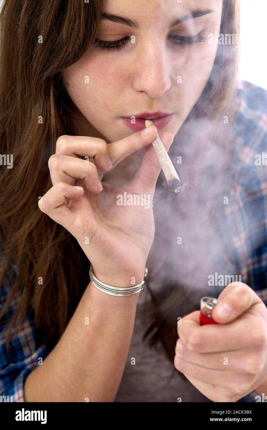 Teenager smoking. Teenage girl smoking a tobacco cigarette. Tobacco contains cancer-causing ...