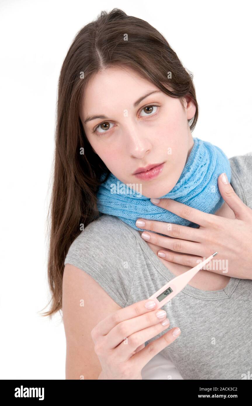 Woman using a digital thermometer. The body temperature reading is 40.3 ...