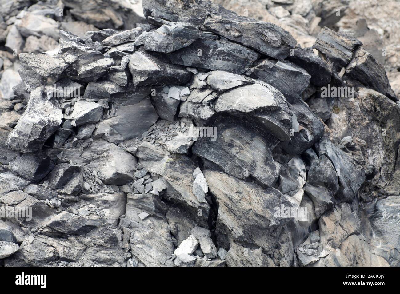 Obsidian flow. Close-up of a rock face made of obsidian. This ...