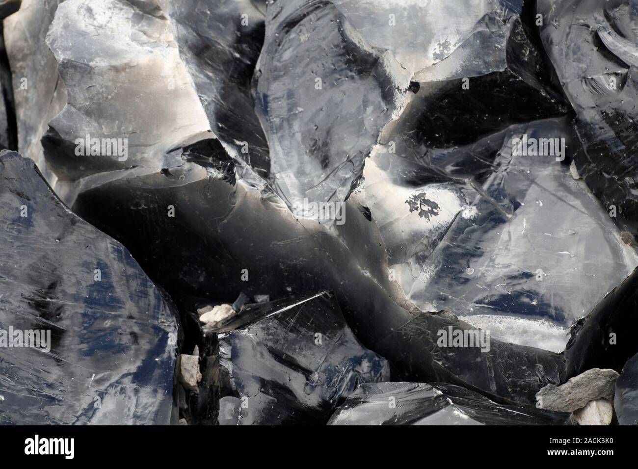 Obsidian flow. Close-up of a rock face made of obsidian. This ...