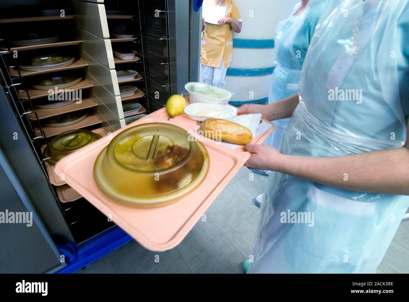 Hospital meal preparation. Hospital worker serving meals to patients ...