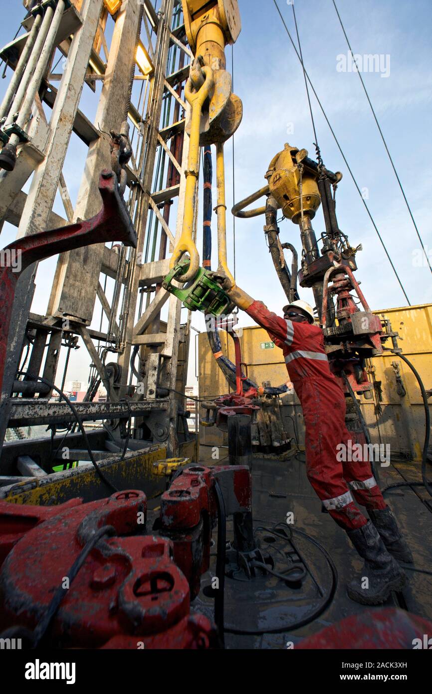 Geothermal well construction. Worker drilling a new well at the site of ...