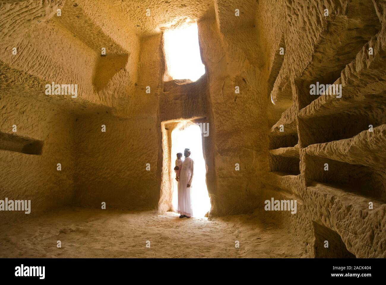 Mada'in Saleh. Man and his child inside a rock tomb in the ancient city ...