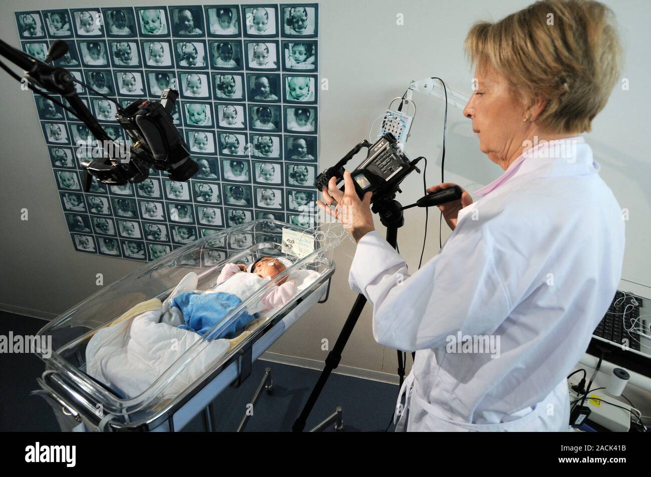 Child development research. Researcher using setting up video cameras ...