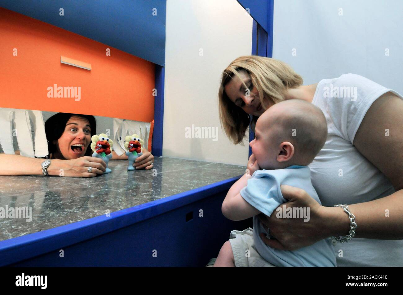 Child development research. Researcher watching a baby's facial ...