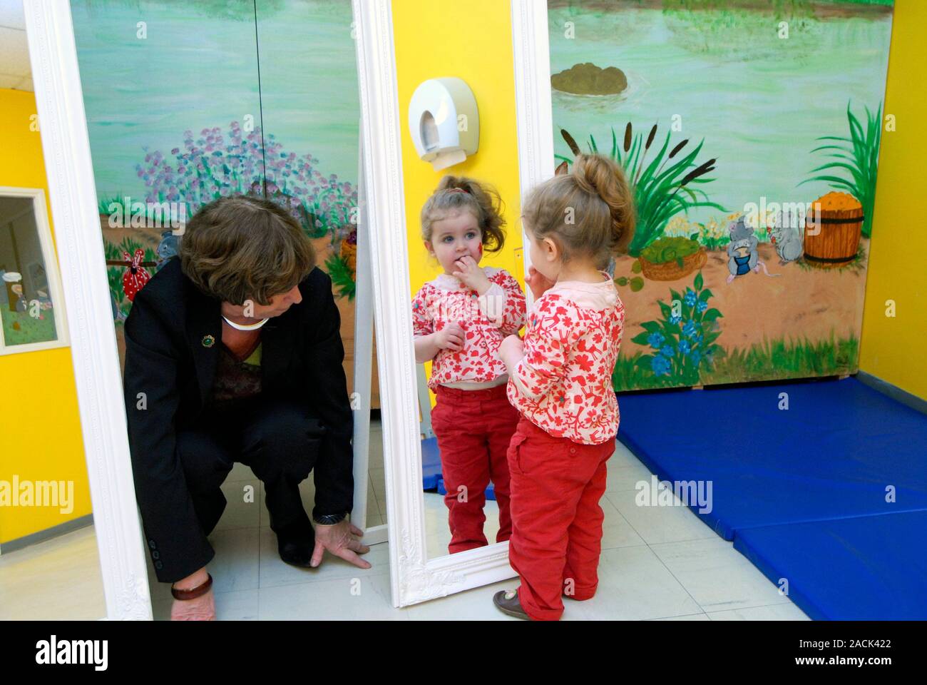 Child development research. Researcher observing a child in front of a ...