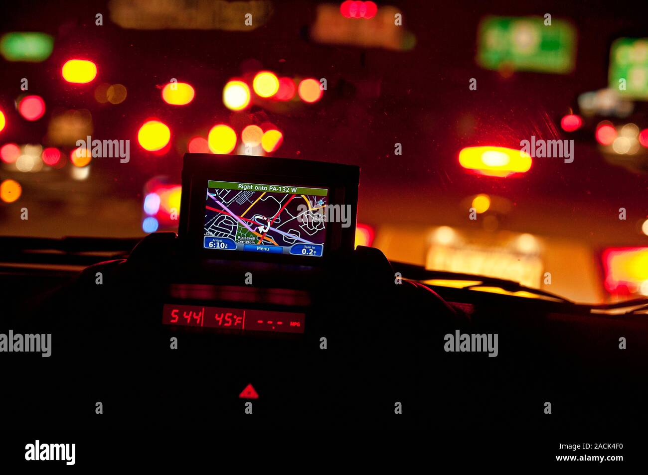 GPS unit in the window of a car in traffic at night. Satellite ...