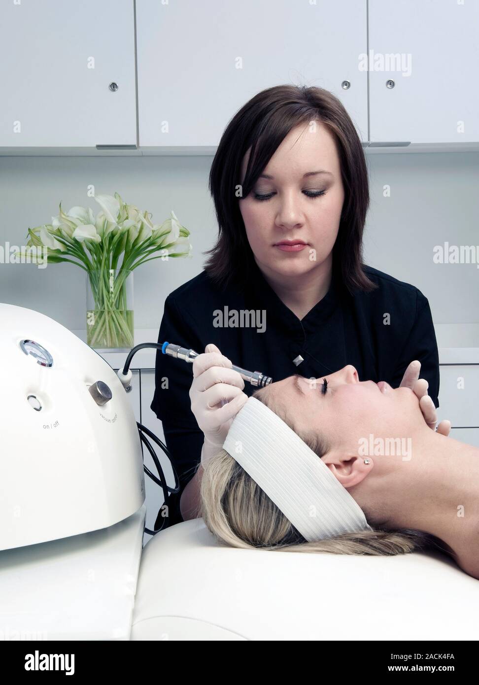 Dermaplaning cosmetic procedure. Machine and tool being used by a ...