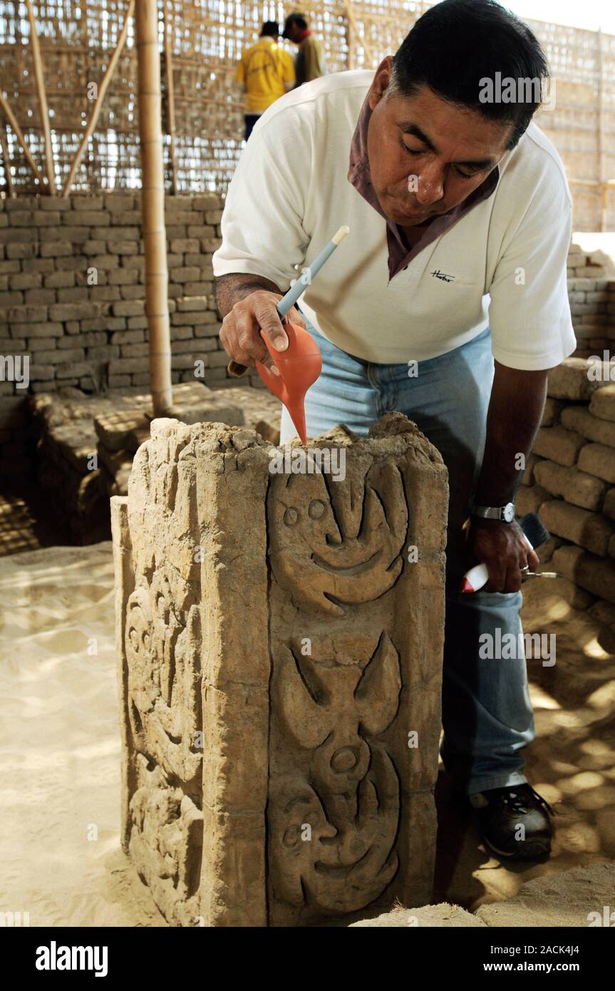 Ancient Peruvian carvings. Archaeologist cleaning bas-relief carvings ...