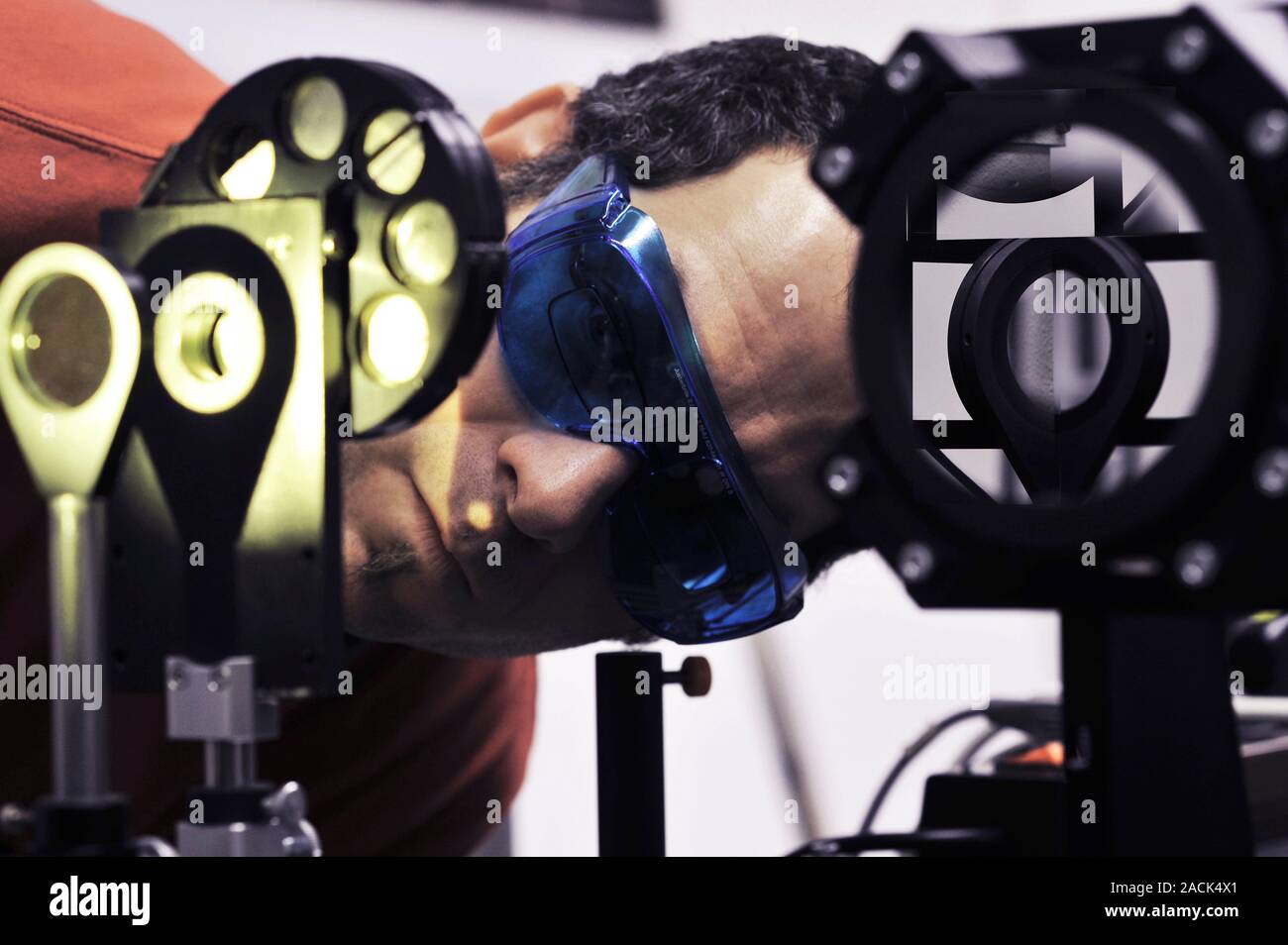 Optical science lab. Scientist working with equipment used for ...
