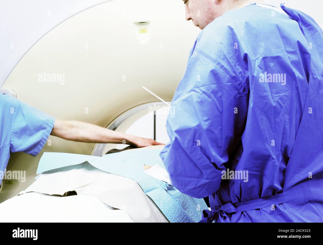 CT scan. Radiologists preparing a patient for a computed tomography (CT ...