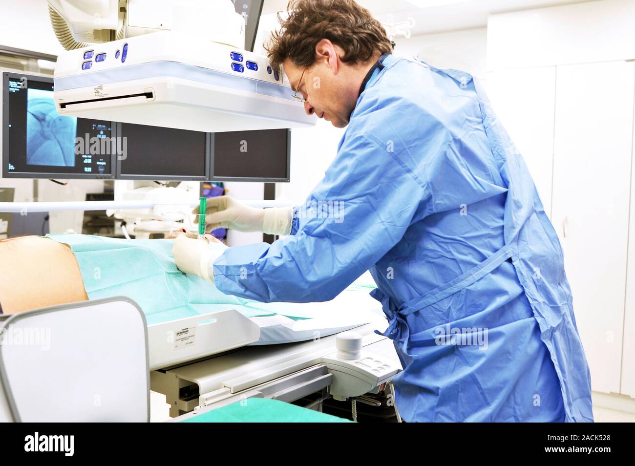CT scan. Radiologist injecting a patient with contrast medium prior to ...