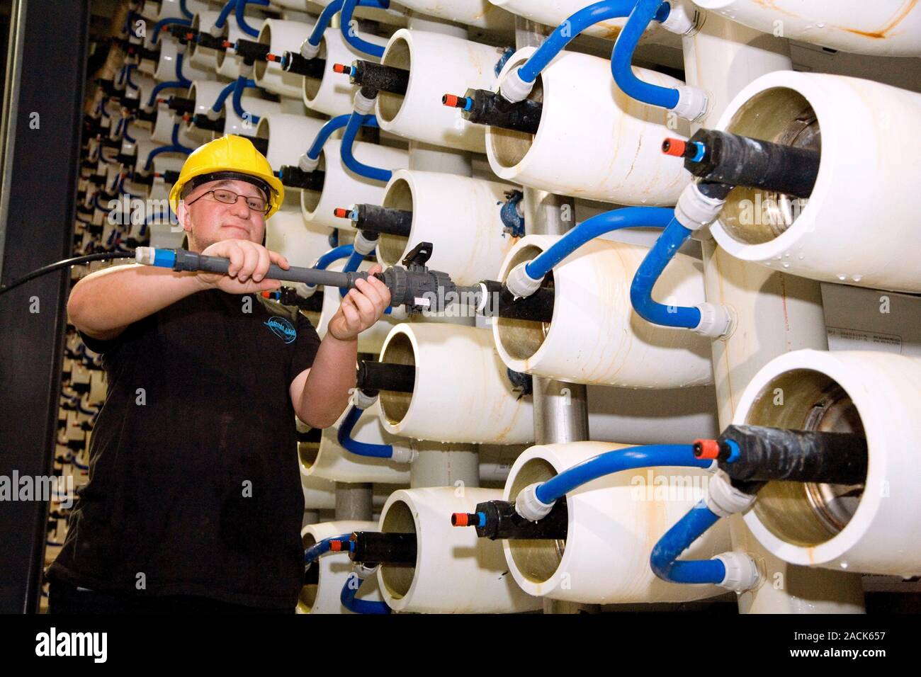 Desalination plant. Technician testing the reverse osmosis membranes at ...