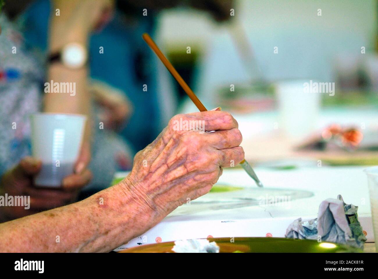 Geriatric care. Elderly patient painting on the geriatric ward of a ...