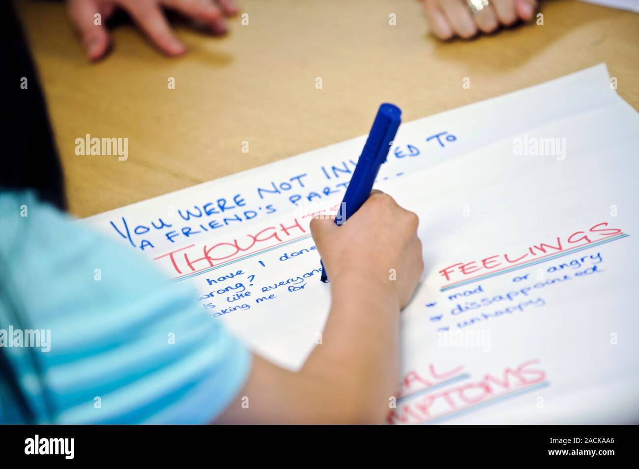 Child writing about thoughts and feelings during a school lesson Stock ...
