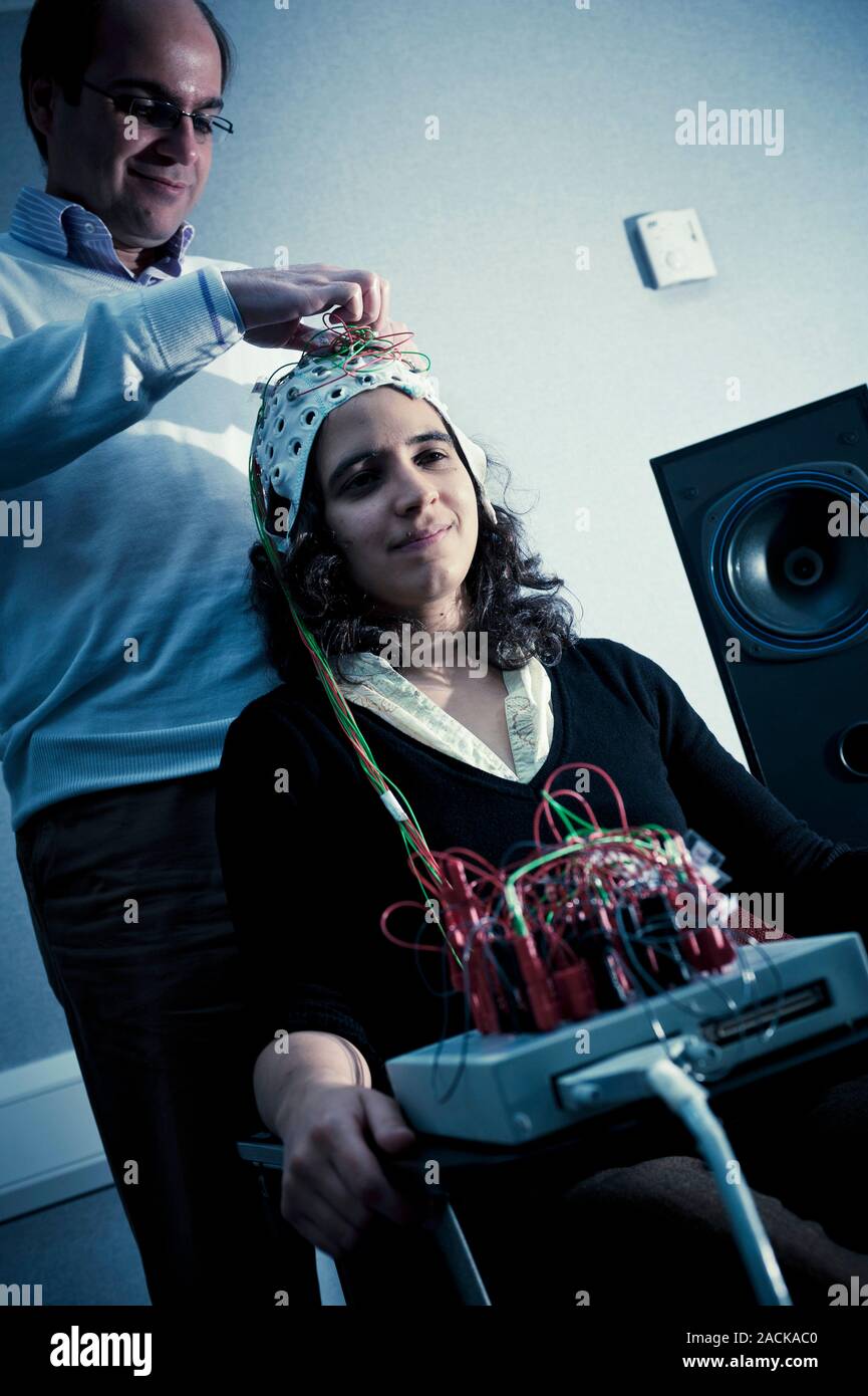 Deafness research. Scientist attaching electroencephalogram (EEG ...
