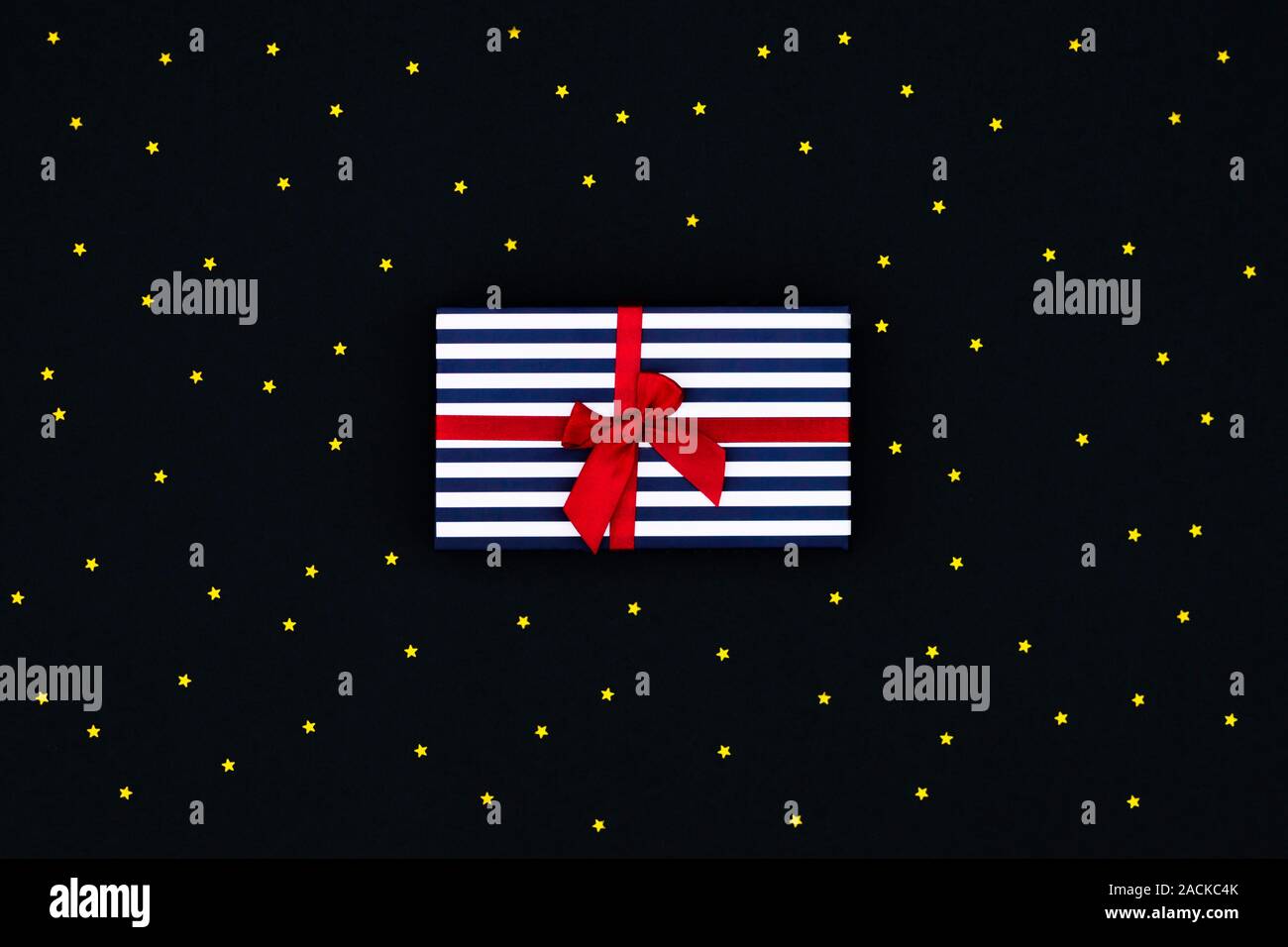 Gift Striped Blue Box With A Red Satin Bow On The Black Background With gift-striped-blue-box-with-a-red-satin-bow-on-the-black-background-with