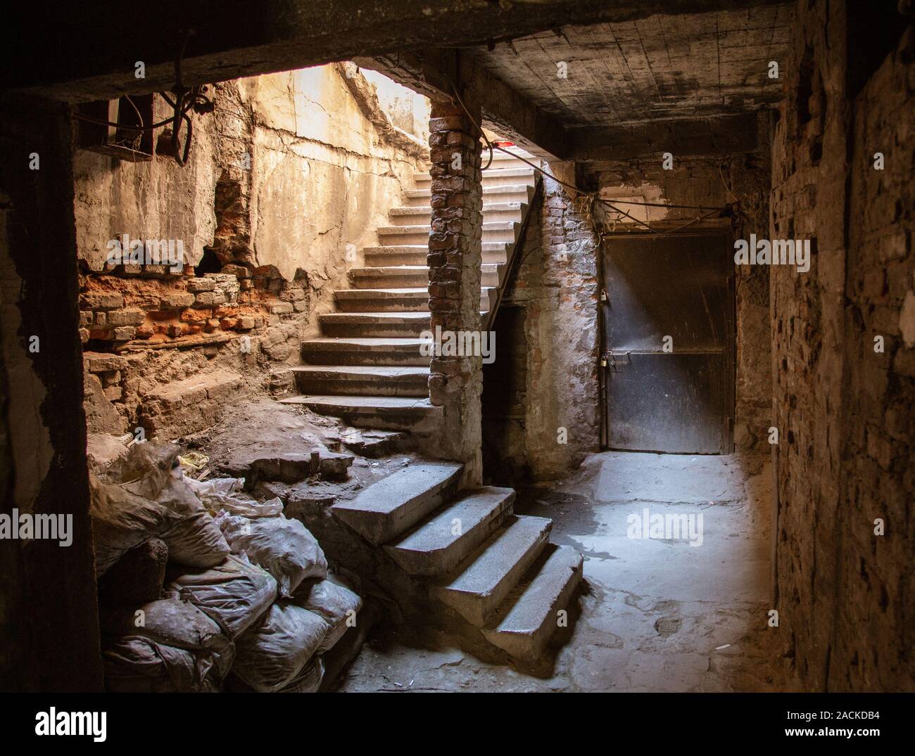 Old abandoned tunnel in the slum underground cellar. Entrance to urban catacombs. Underside of ...