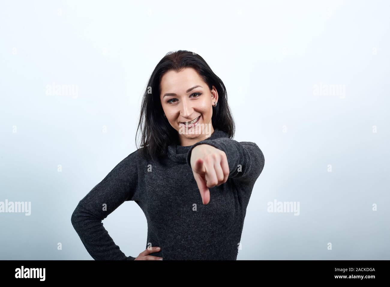 Beautiful caucasian young woman pointing finger at camera, smiling ...