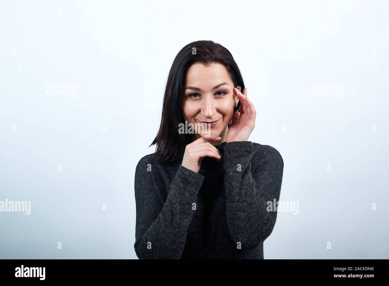 Attractive caucasian young woman holding hand on face, model gesture ...