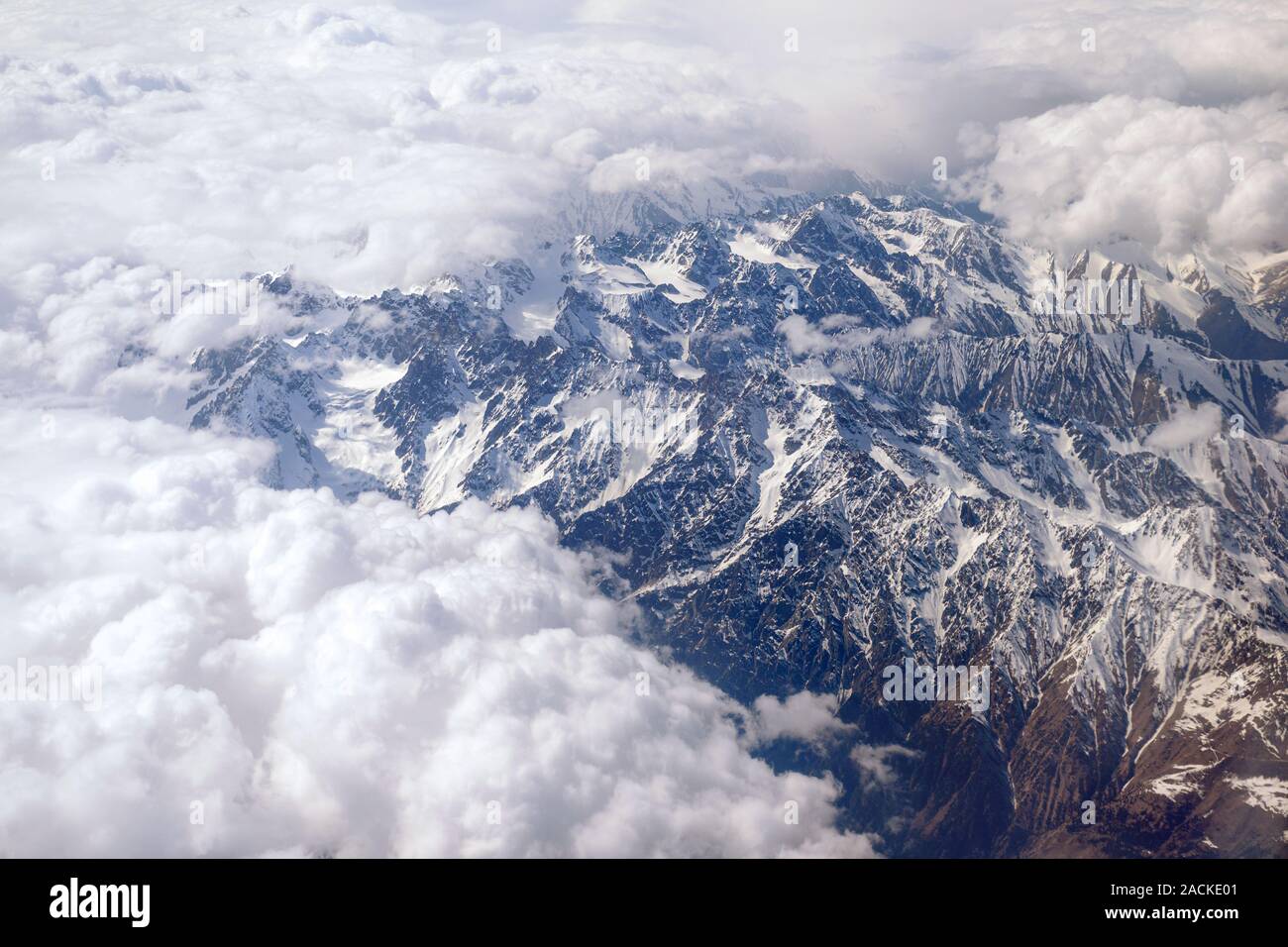 Aerial view of the mountain ranges. View through the clouds to the ...