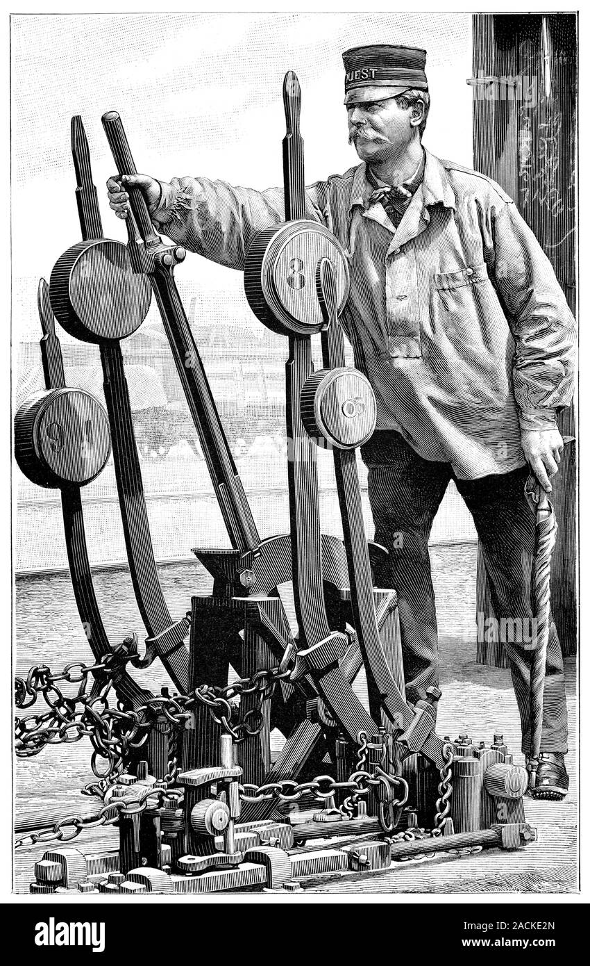 Railway signalman operating train track switches and holding a furled ...