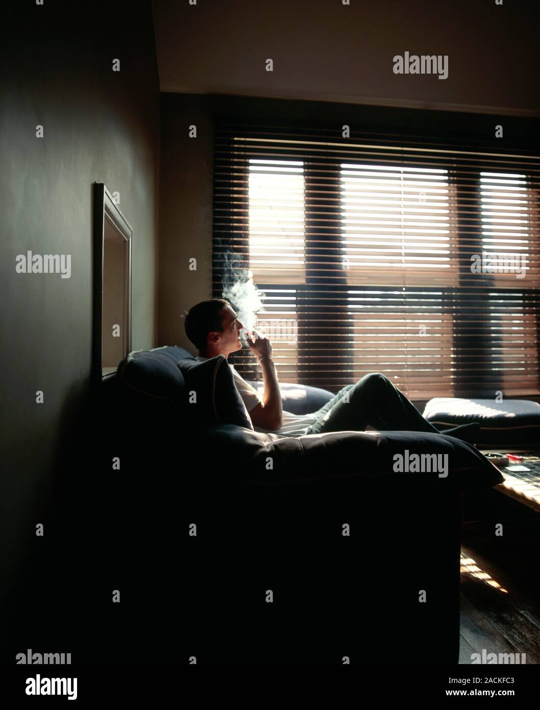Smoking at home. Man smoking in the living room of a house Stock Photo ...