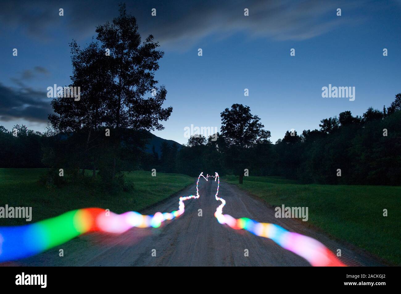 Lights trails. Time-exposure image of coloured light trails along a ...
