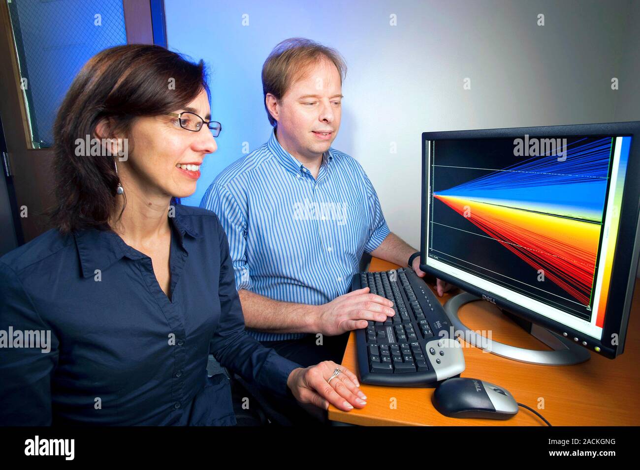 Bacteria research. Microbiologists (background) studding microarray ...
