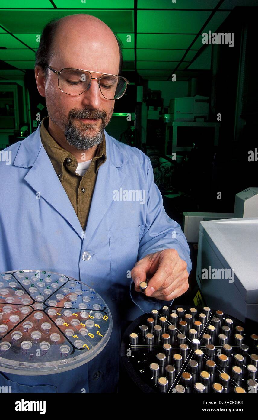 Agricultural soil research. Chemist loading Brazilian soil samples into ...