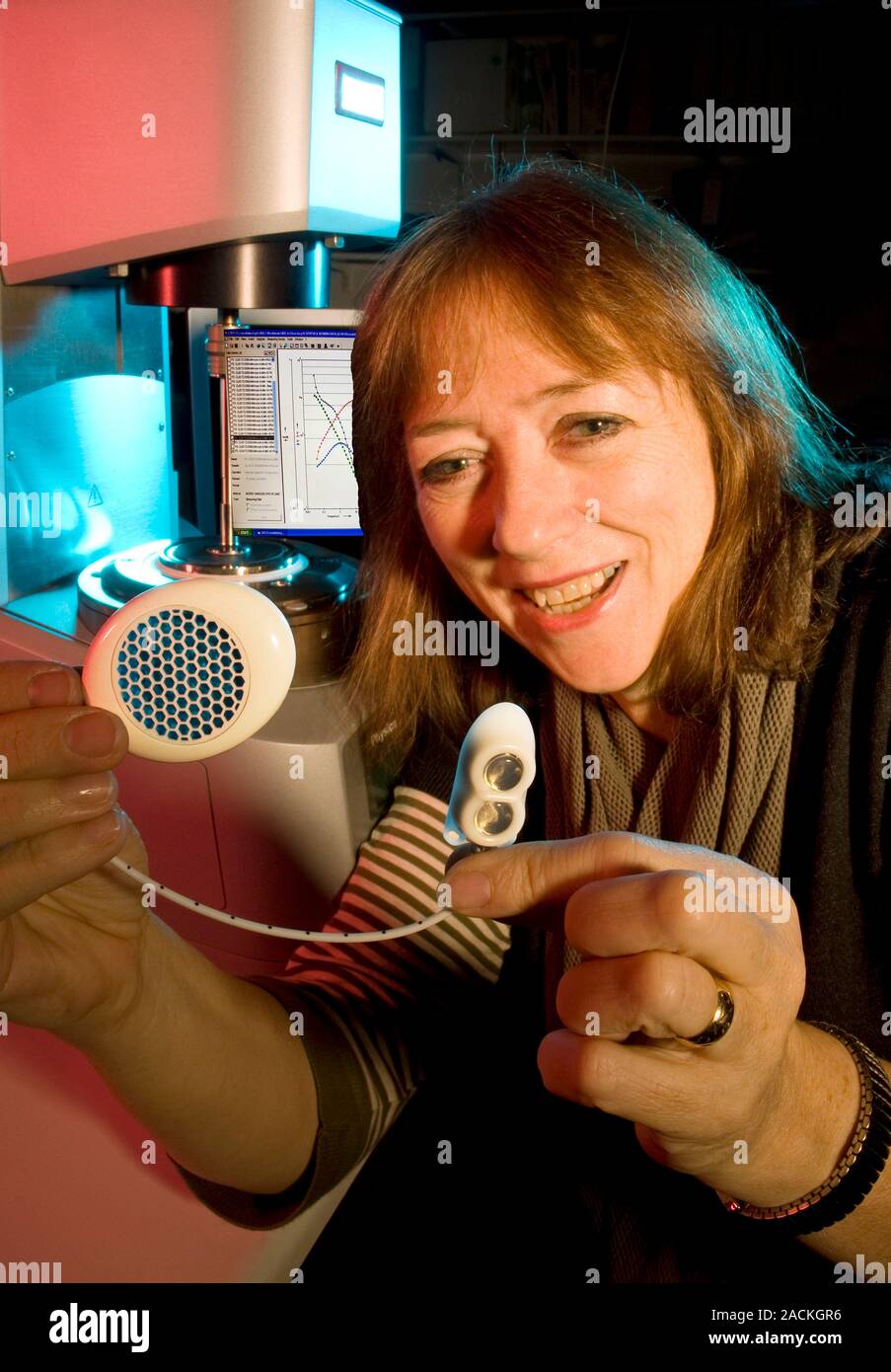 Artificial pancreas. Researcher in her lab, holding the artificial ...