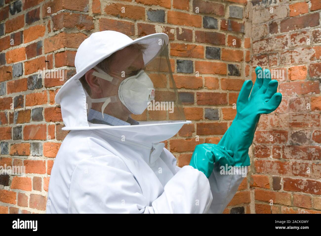 Operative donning protective clothing in preparation to deal with an ...
