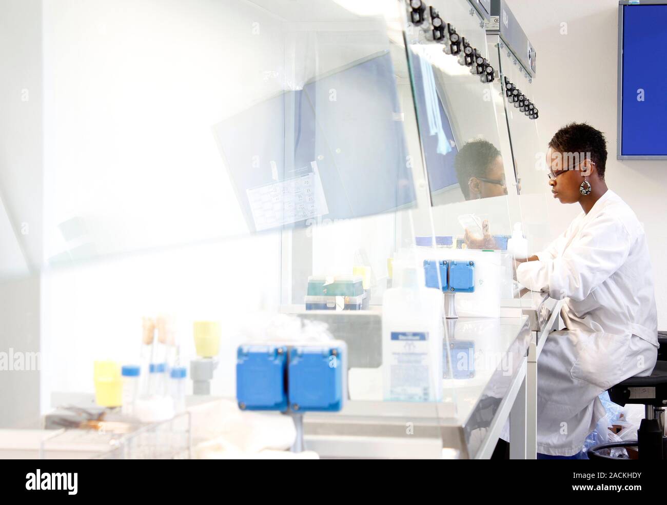 Female scientist wearing a white coat conducts research with cell ...